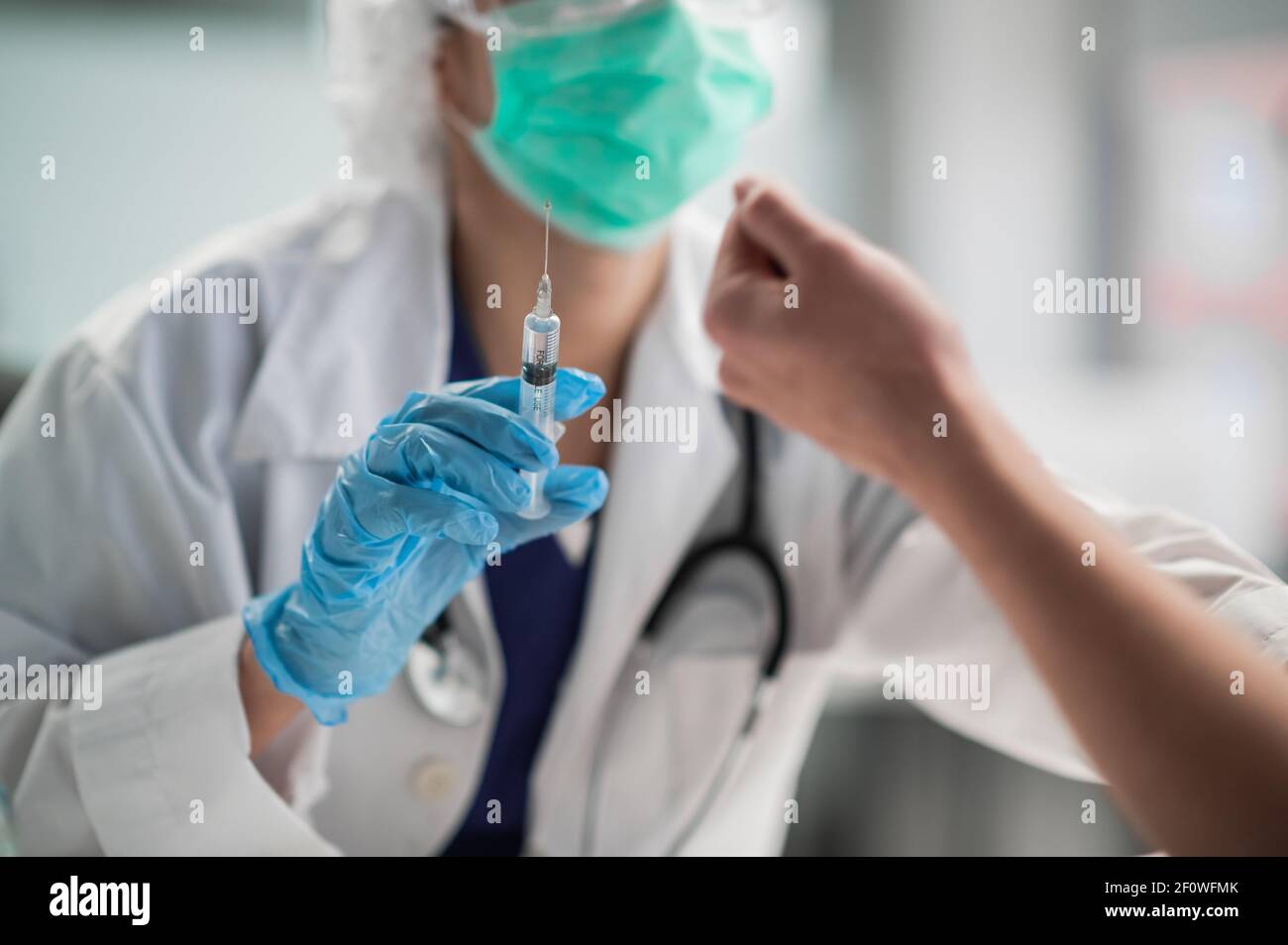 A young nurse releases air and excess medicine from the syringe before ...