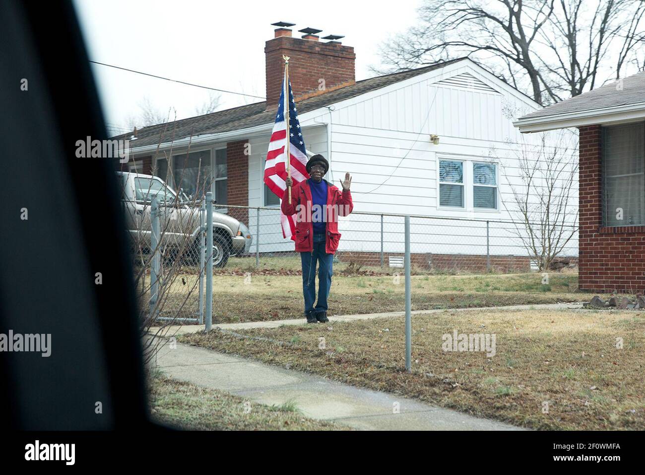 A local resident waves as President Barack Obama travels by motorcade ...
