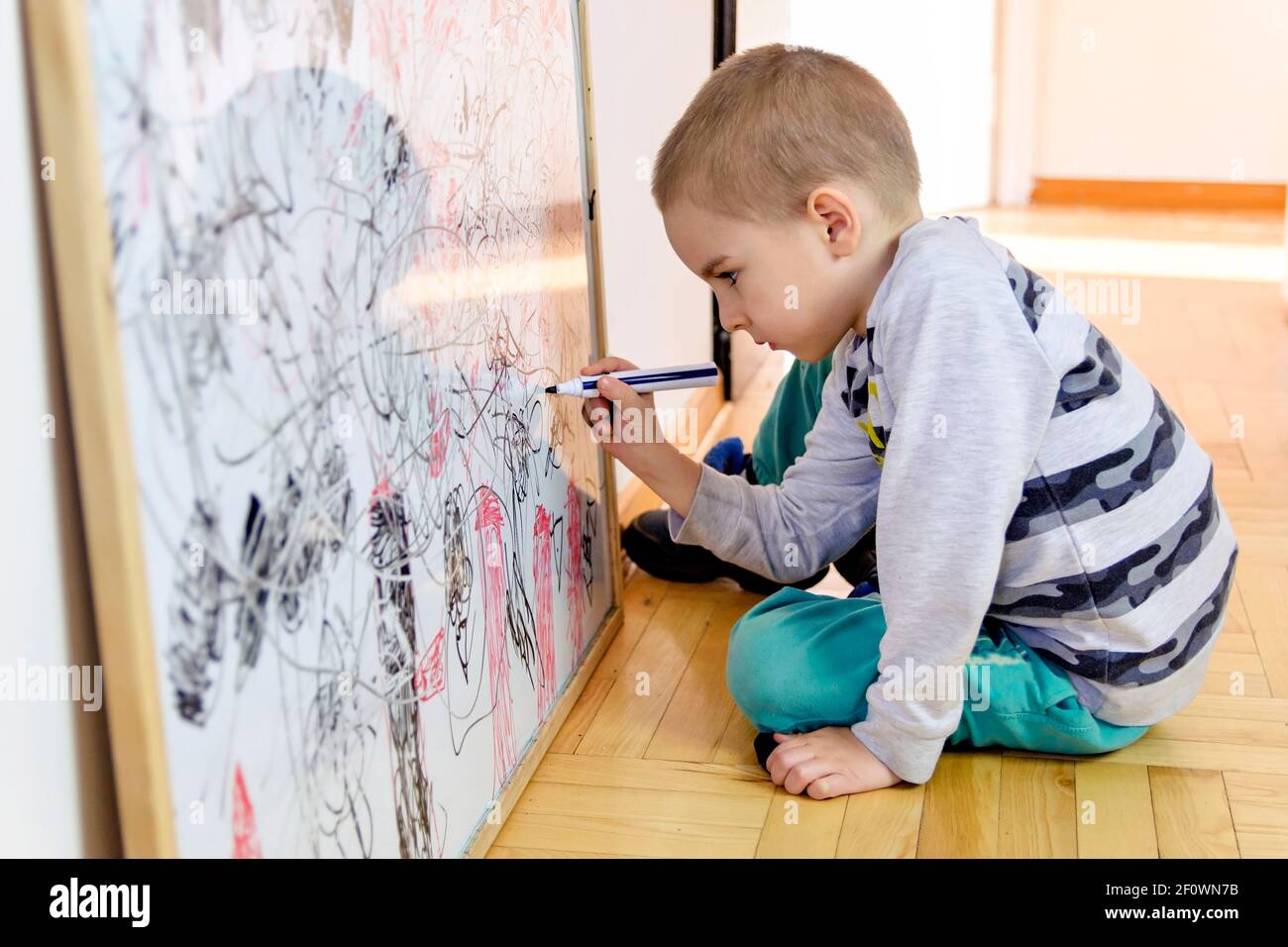 Cute little boy drawing on white board Stock Photo - Alamy