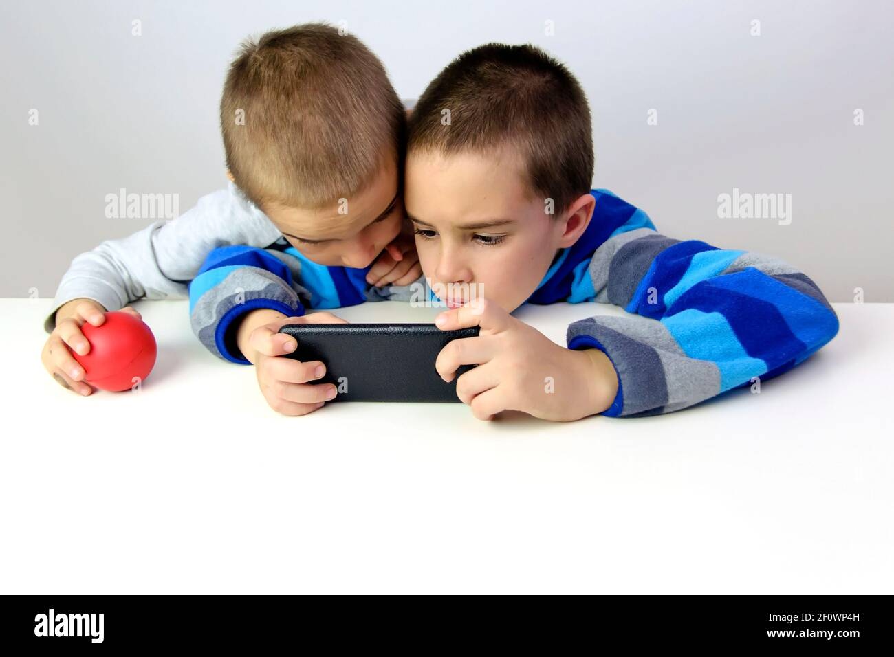 Two little boys playing a game on the smartphone Stock Photo - Alamy