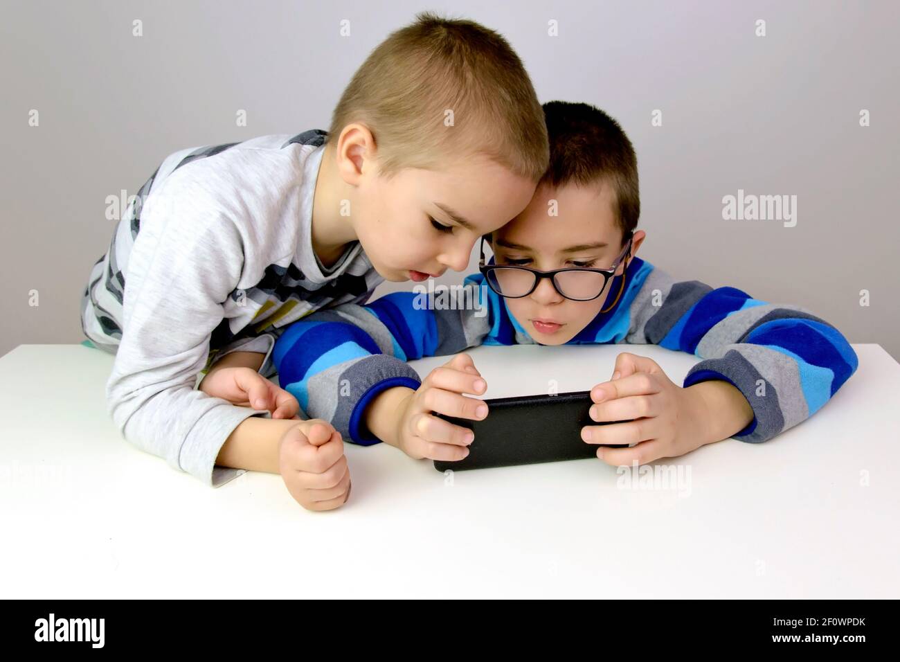 Two little boys playing a game on the smartphone Stock Photo - Alamy