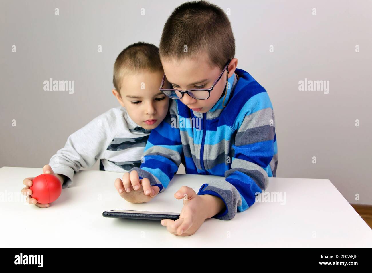 Two little boys playing a game on the smartphone Stock Photo - Alamy