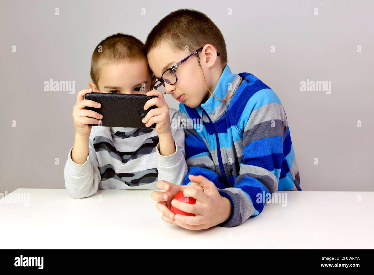 Two little boys playing a game on the smartphone Stock Photo - Alamy