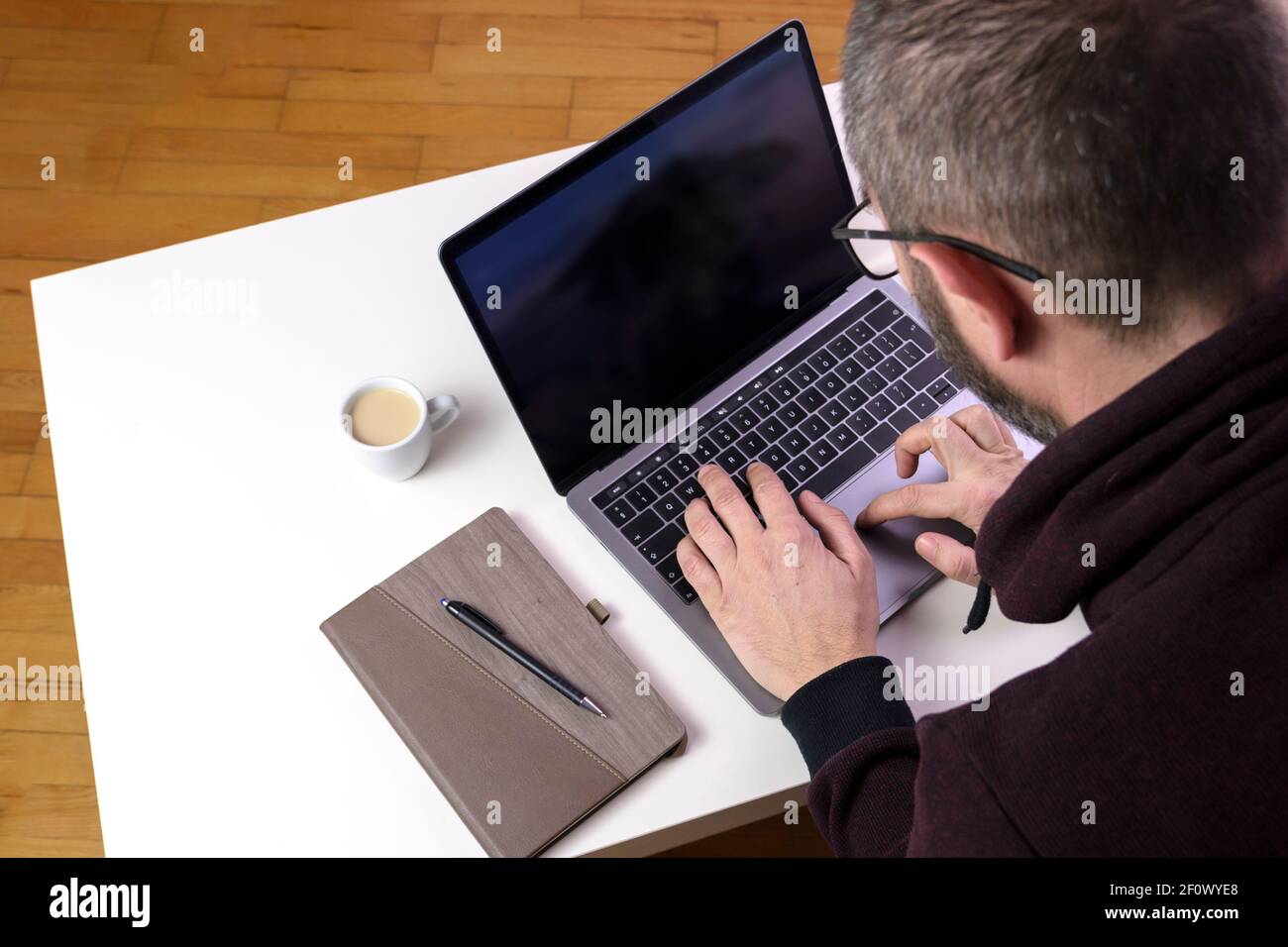 Back view of man working on laptop Stock Photo - Alamy