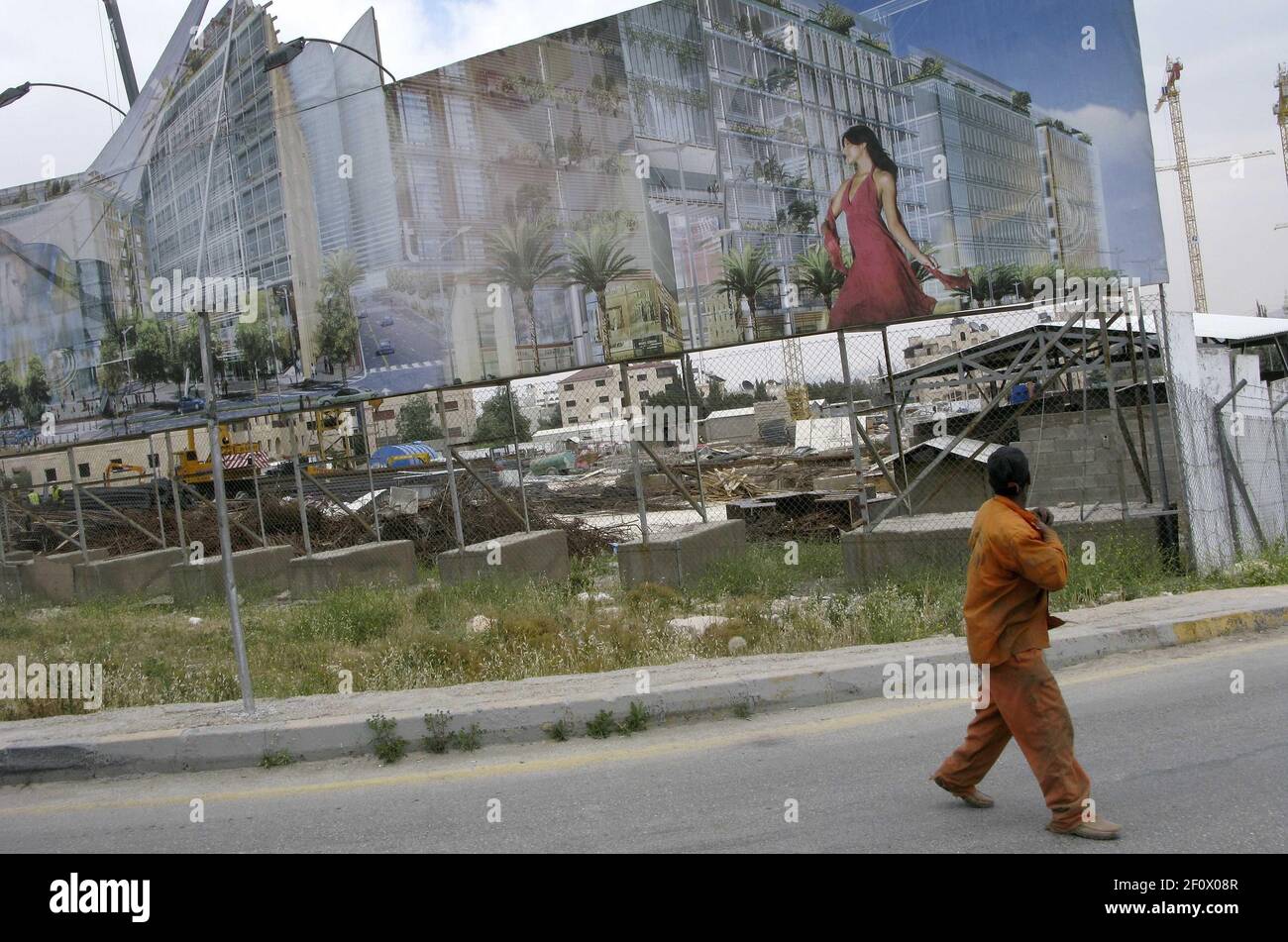 April 2008- Amman, Jordan- A road cleaner looks at a billboard ...