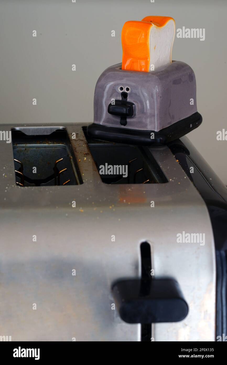 A steel and black toaster with a miniature ceramic toaster Stock Photo ...