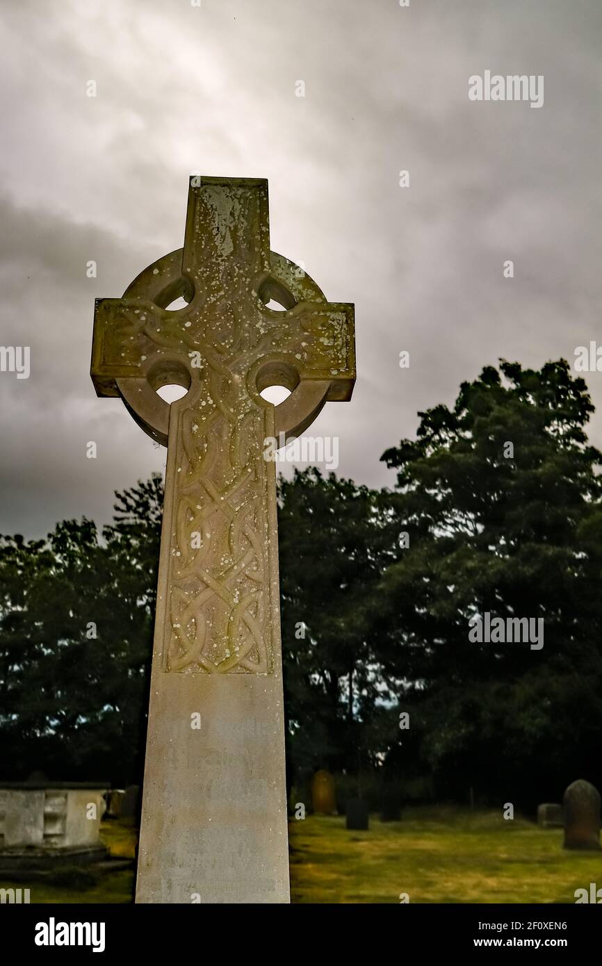 Ornate concrete cross in the church yard of St Benedicts church in the ...