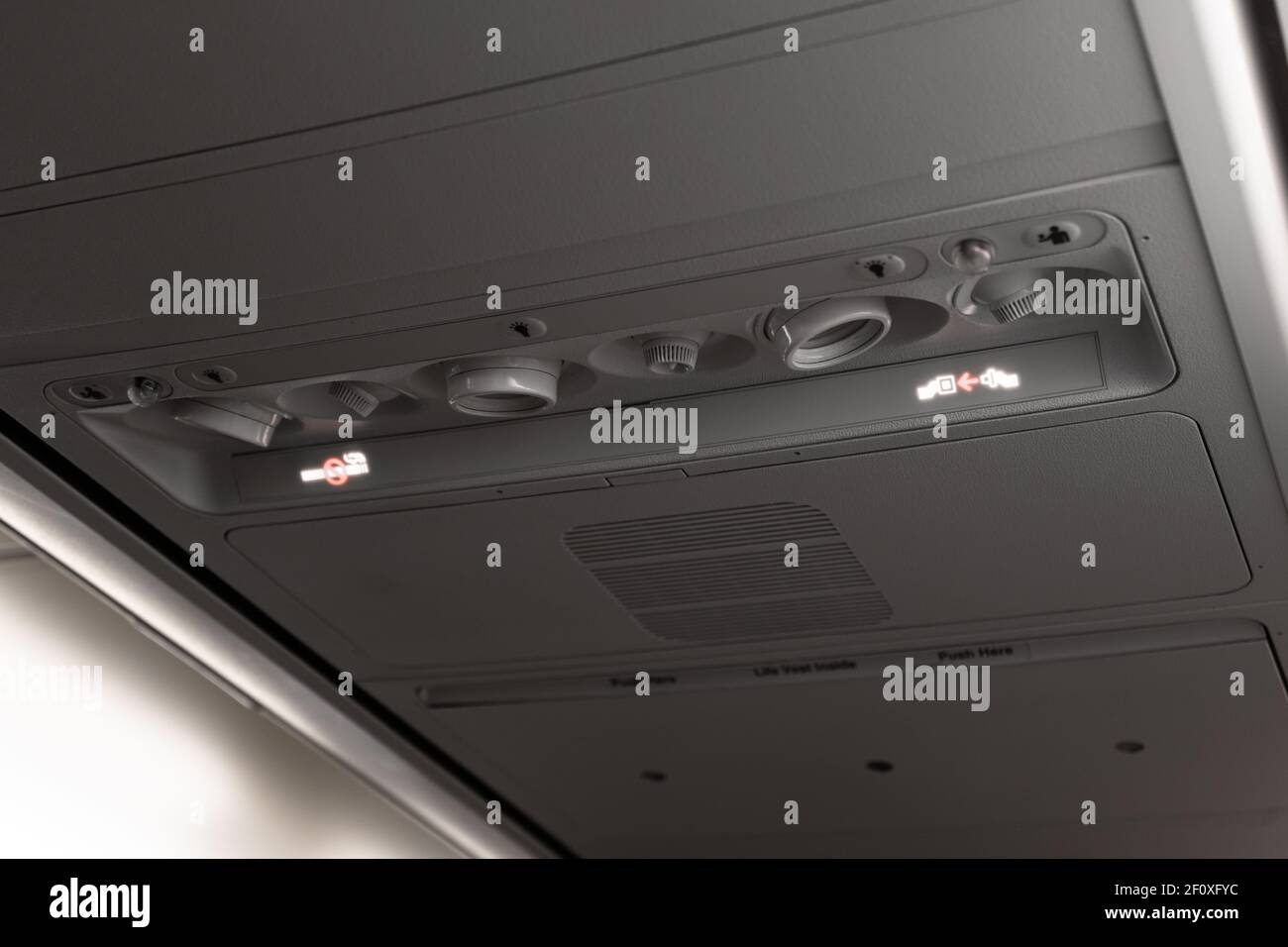 Overhead panel with lights, air conditioning and safety signs in the ...