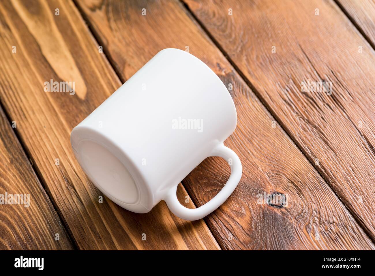 Mockup of white cup laying on wooden table Stock Photo - Alamy