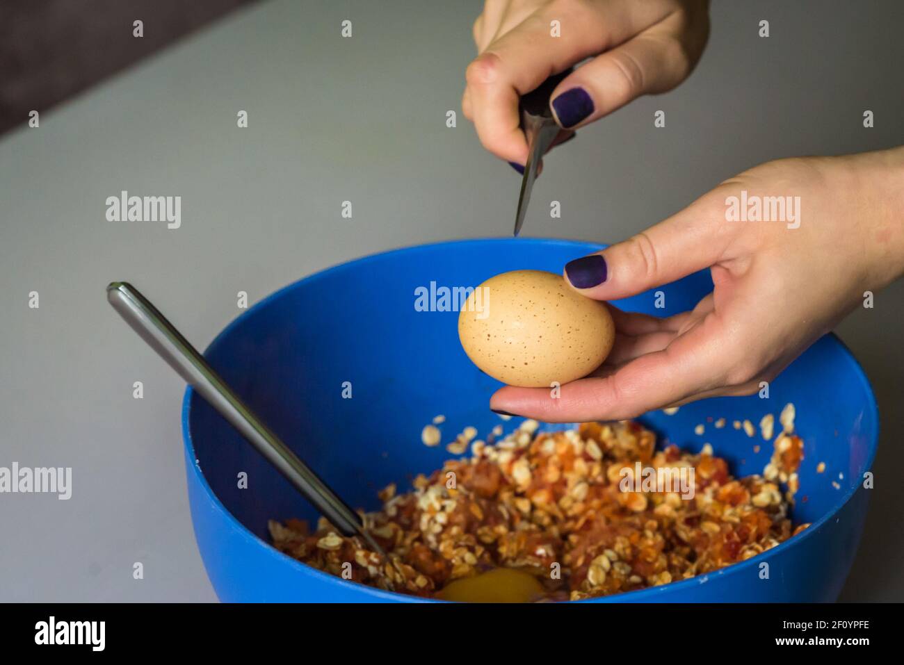 Hand beats raw egg knife Stock Photo - Alamy