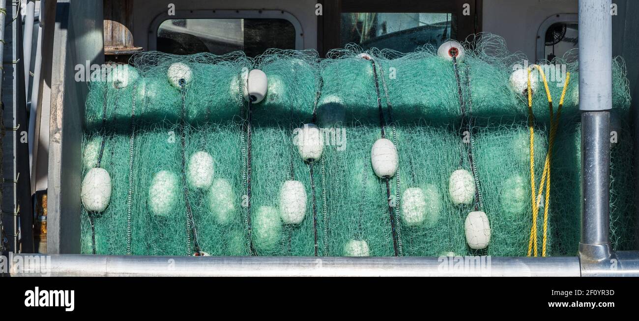 giant roll of aqua green fishing netting with white floats on a boat ...
