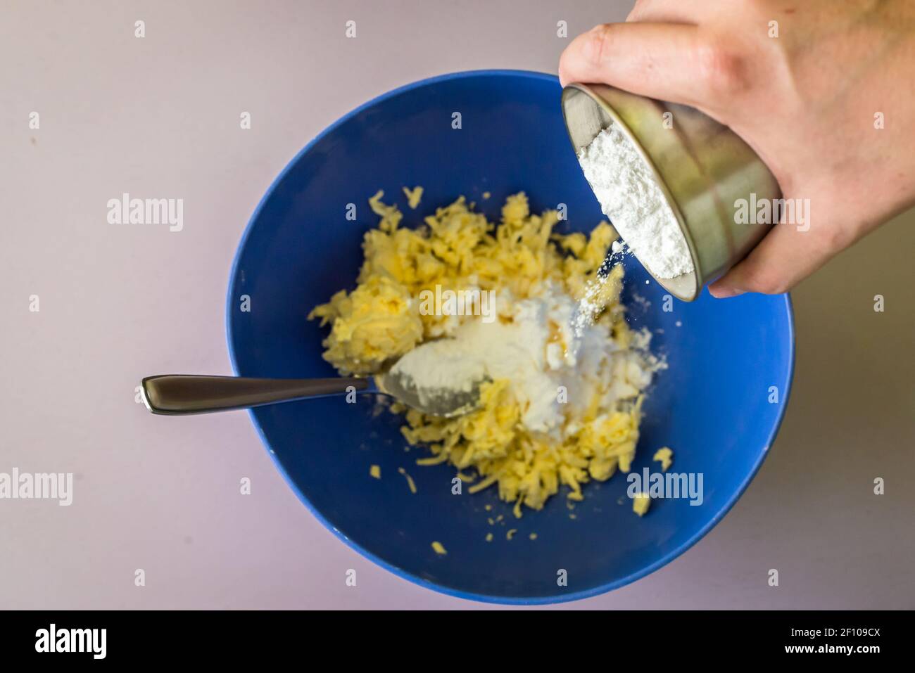 Hand adds powdered sugar in butter Stock Photo - Alamy