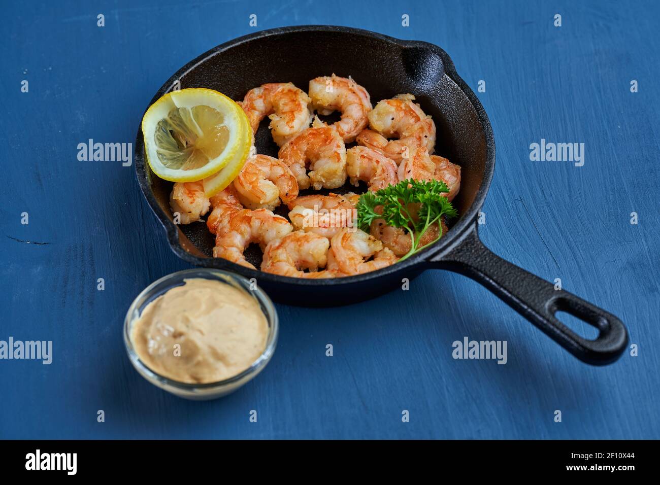 Delicious red king prawns prepared at wok on blue background in a cast ...
