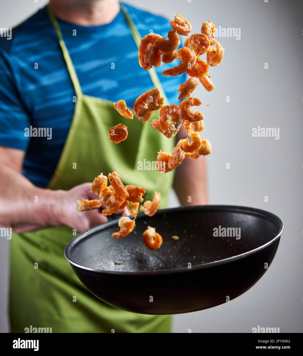 Skillful chef throwing red prawns cooking in a hot wok Stock Photo - Alamy