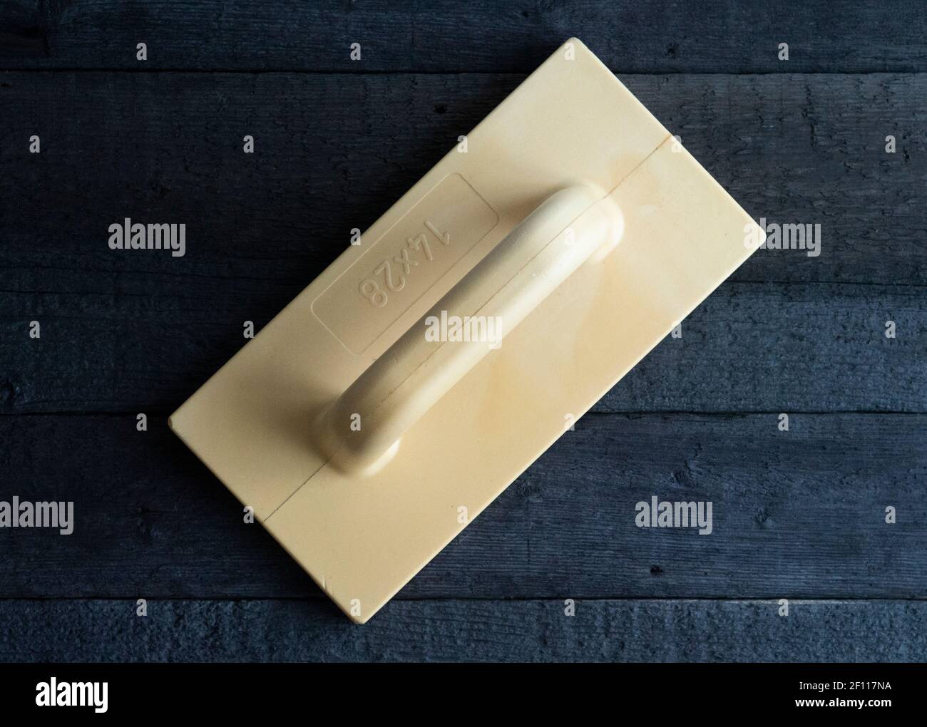 A construction worker plasters concrete against the wall. device for ...