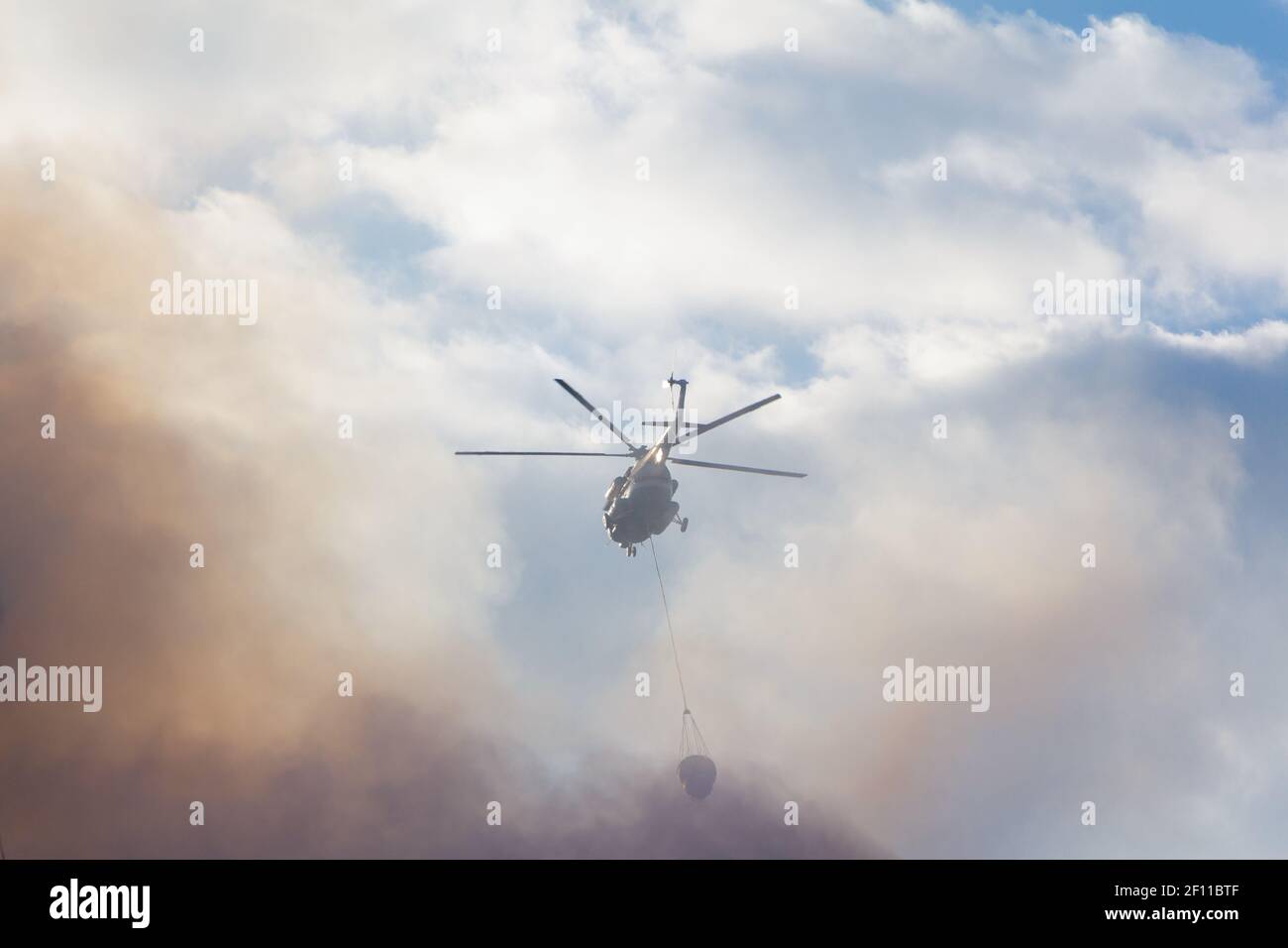 Fire-fighting helicopter against the background of smoke and sky Stock ...