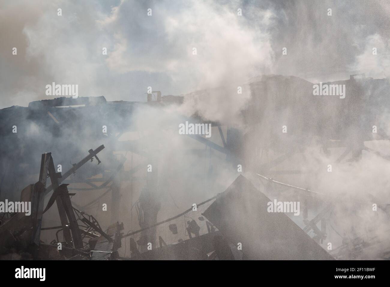 Technological disaster, fire, destroyed industrial building, smoke and ...