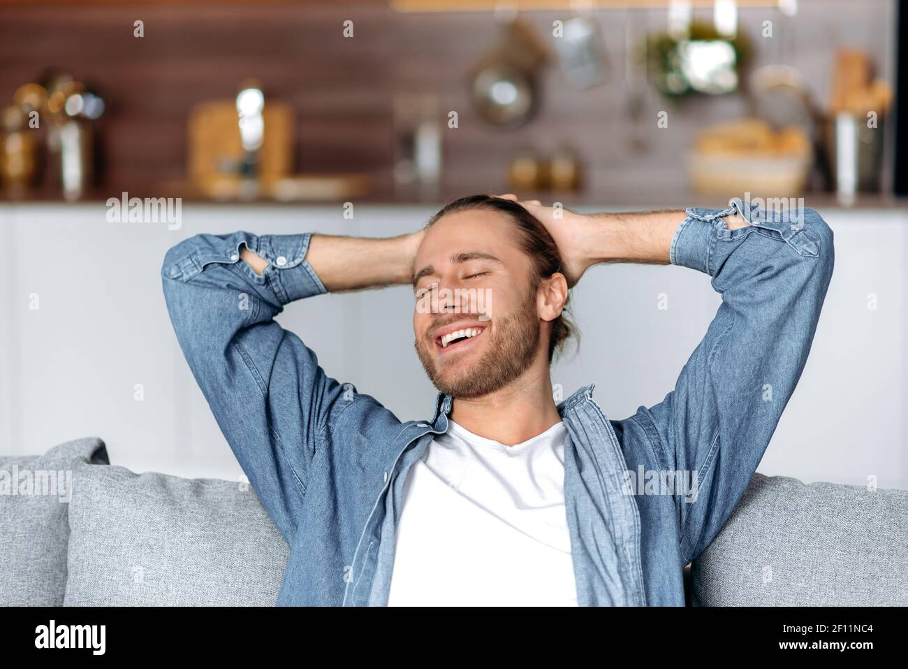 Chilling at home. Handsome happy caucasian guy in casual clothes ...