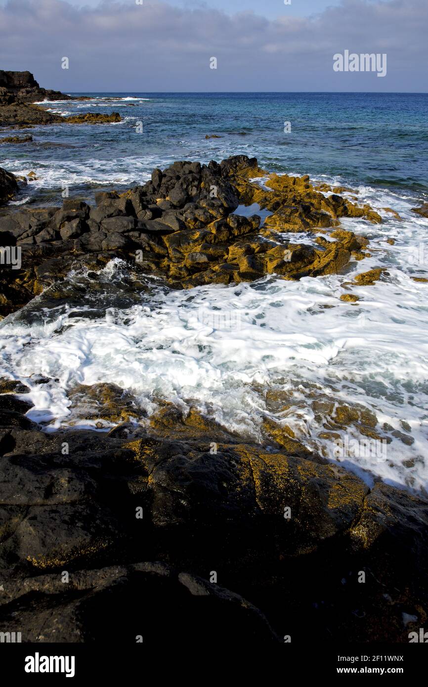 Beach light water foam rock spain landscape sky cloud Stock Photo - Alamy