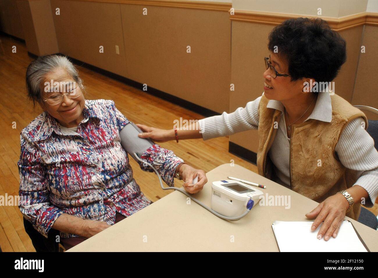 Remy Obillo, right, screens Beatrice Abuan's blood pressure during a ...