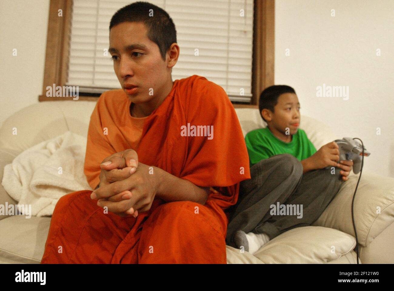 Michael sits in the family living room as his younger brother, Prenz ...