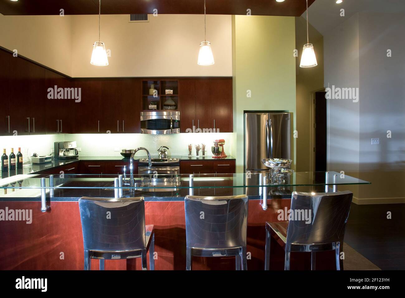 Aluminum Philippe Starck bar stools cozy up to the acid etched glass ...