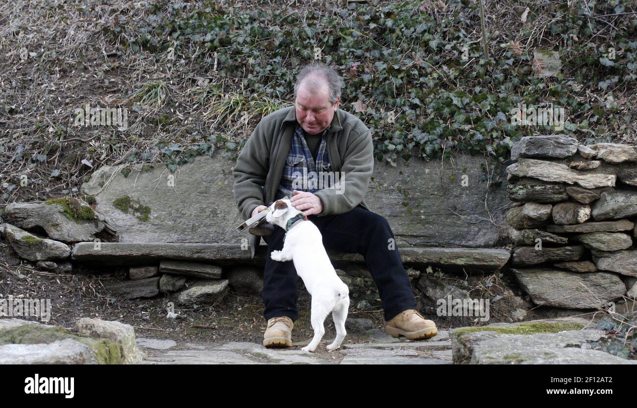 Martin Smith is greeted by a Jack Russell terrier at a terrace garden ...