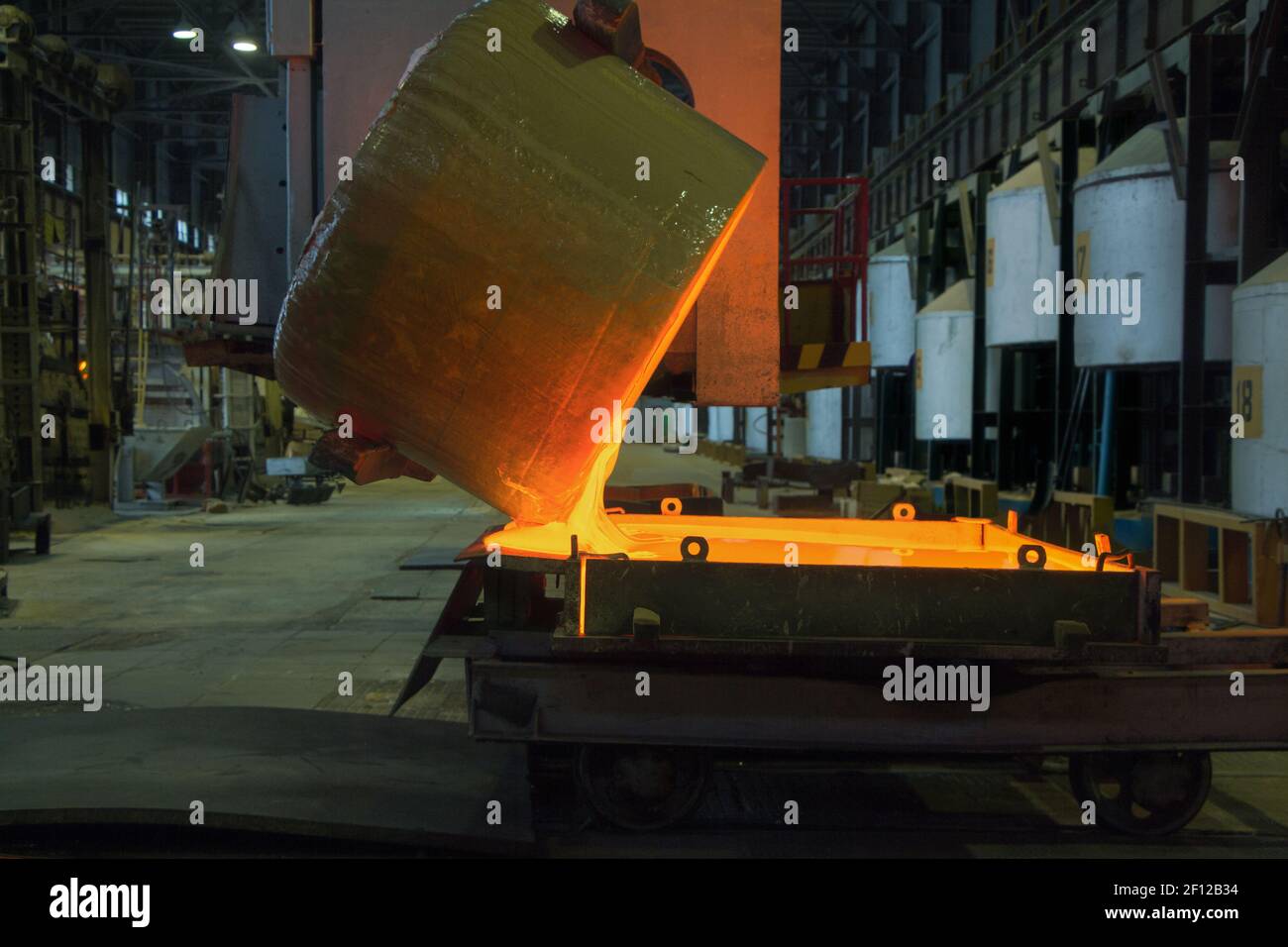 Pouring melted glass into mold in glass factory Stock Photo - Alamy