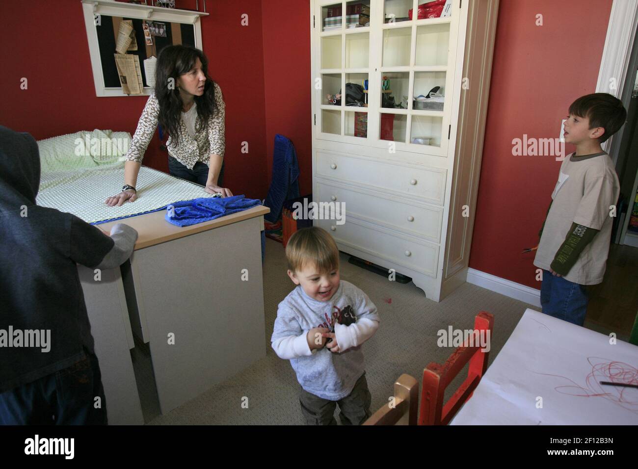Jacqueline McBride tries to do some sewing work as Declan, 2, and Aidan ...