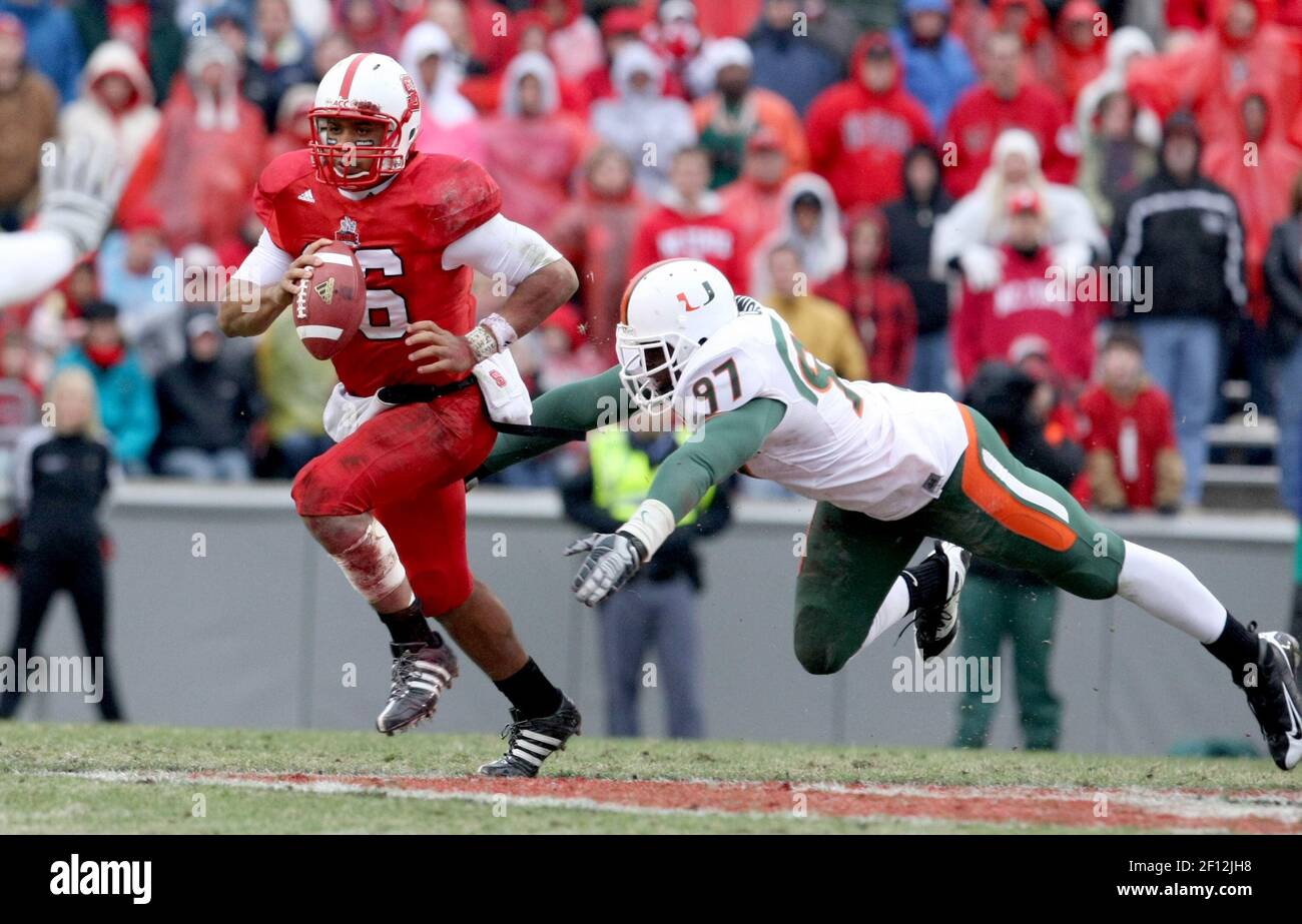 N.C. State's Russell Wilson avoids a tackle by Miami's Adewale Ojomo ...
