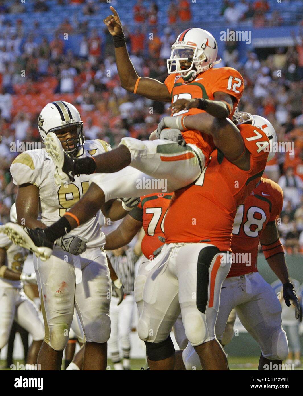 Miami's Jacory Harris is lifted in the air by offensive lineman Orlando ...