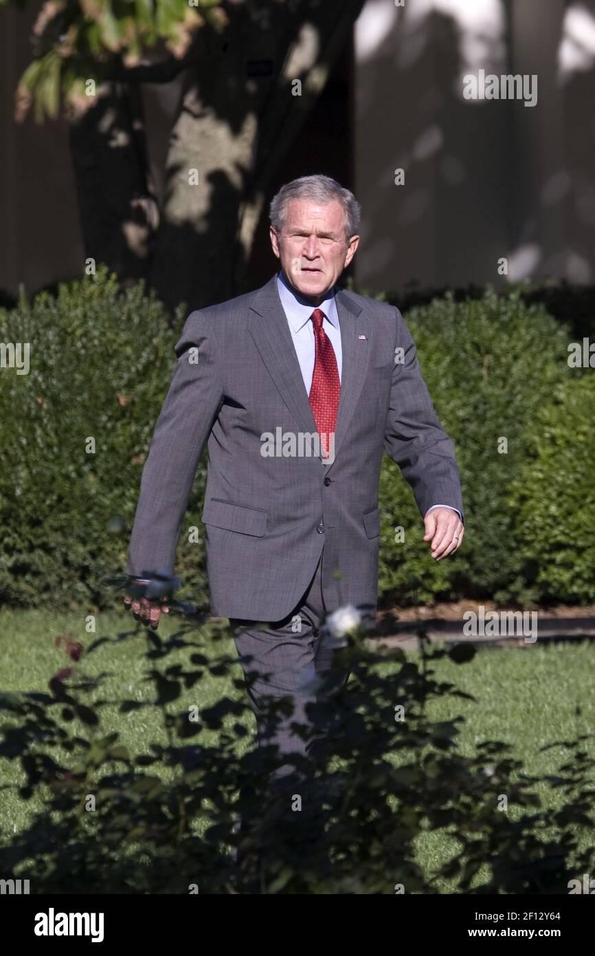 President George W. Bush walks in the Rose Garden to welcome members of ...
