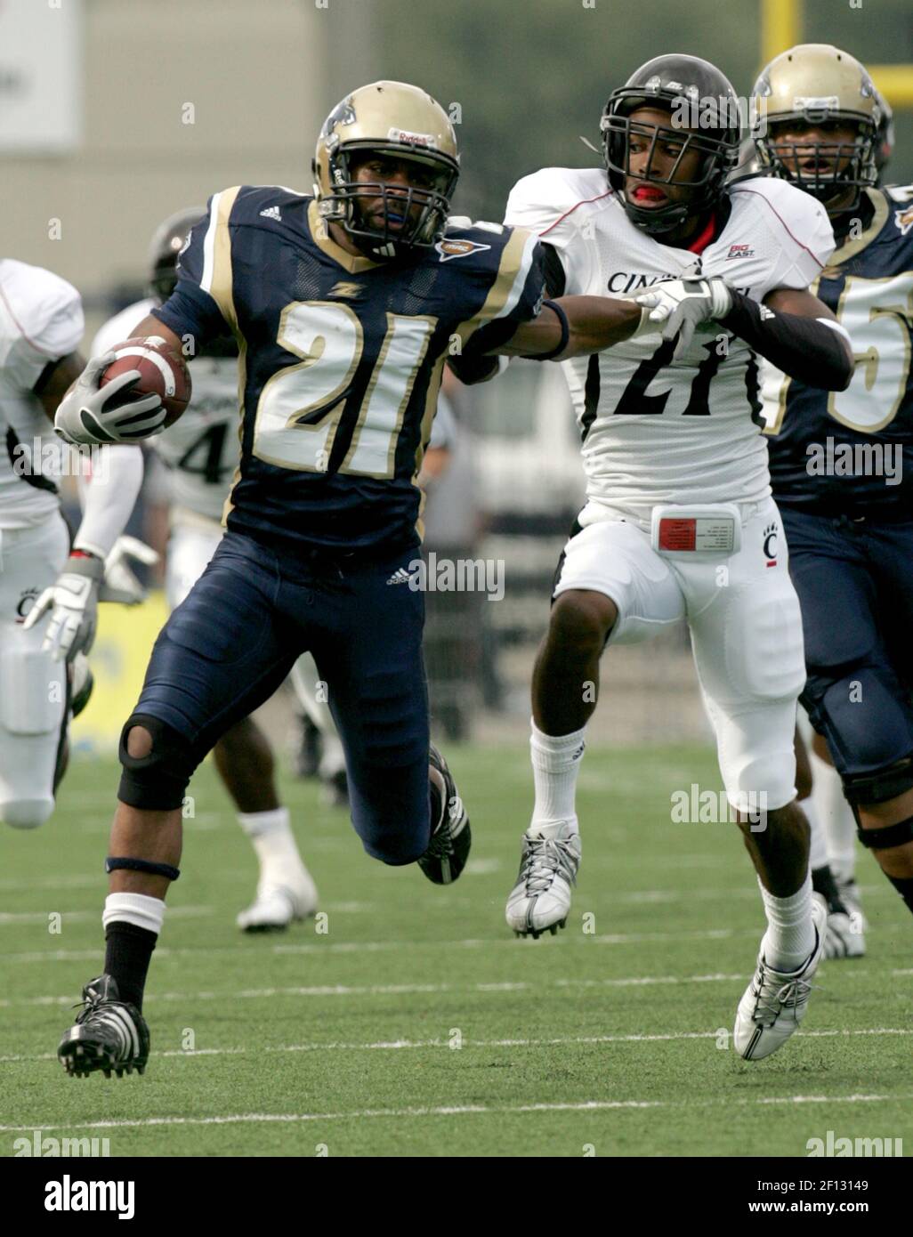 Cincinnati's Mike Mickens makes a grab on Akron's Andre Jones, left ...