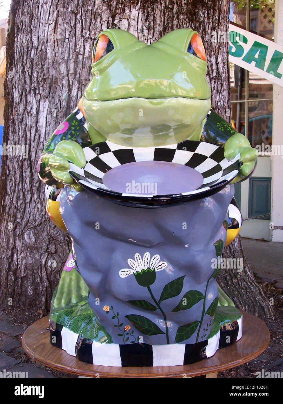A decorative frog statue sits outside a Murphys' art gallery and greets ...