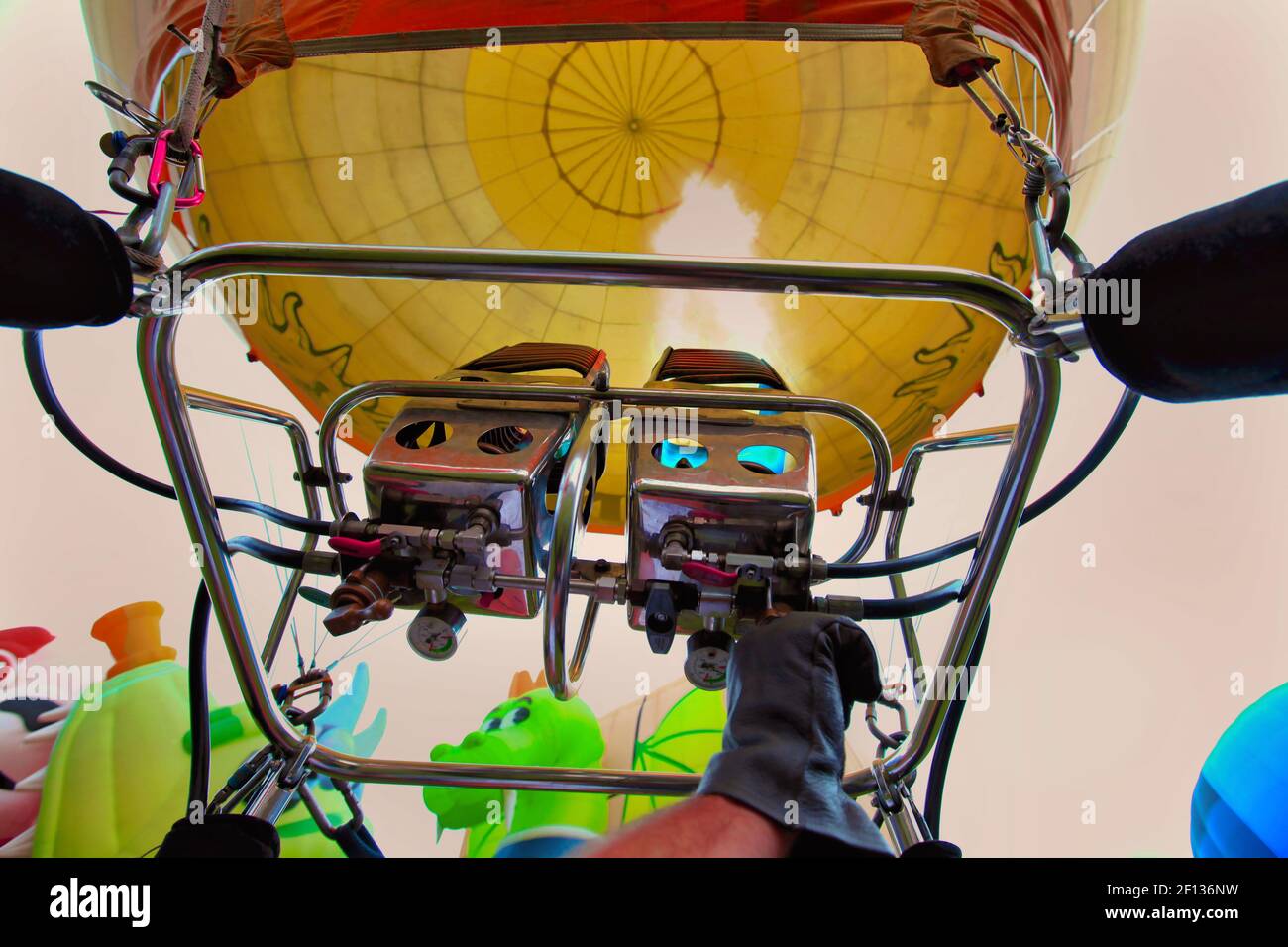Hot Air balloon crew man prepares to rise into the sky by igniting his ...