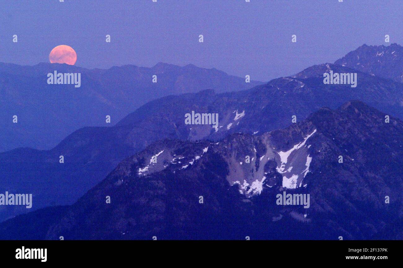 The moon rises from the east in thsi view from Sahale Glacier Camp ...