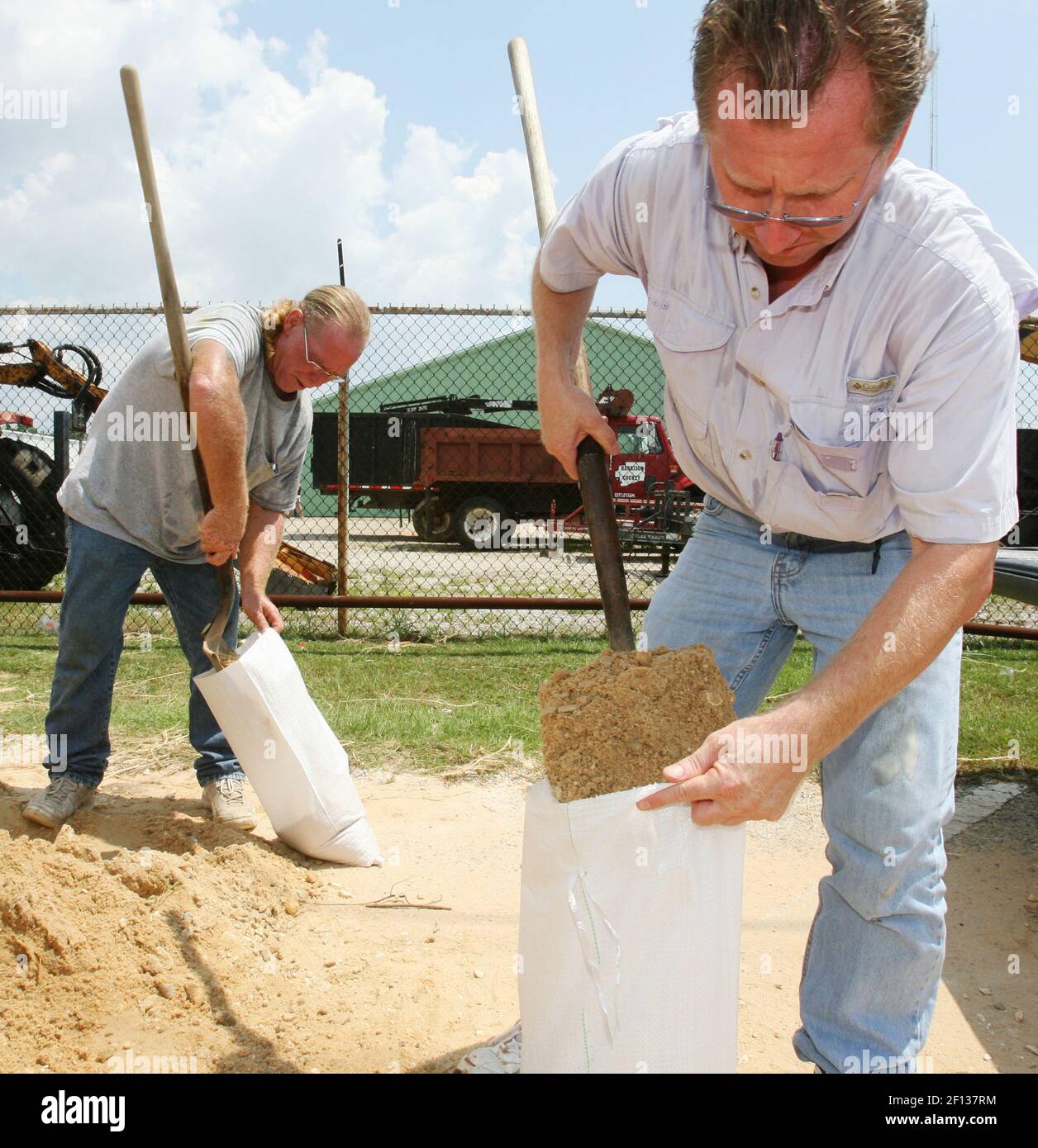 Mike Walls, right, and Randy Summers fill sand bags at the Harrison ...