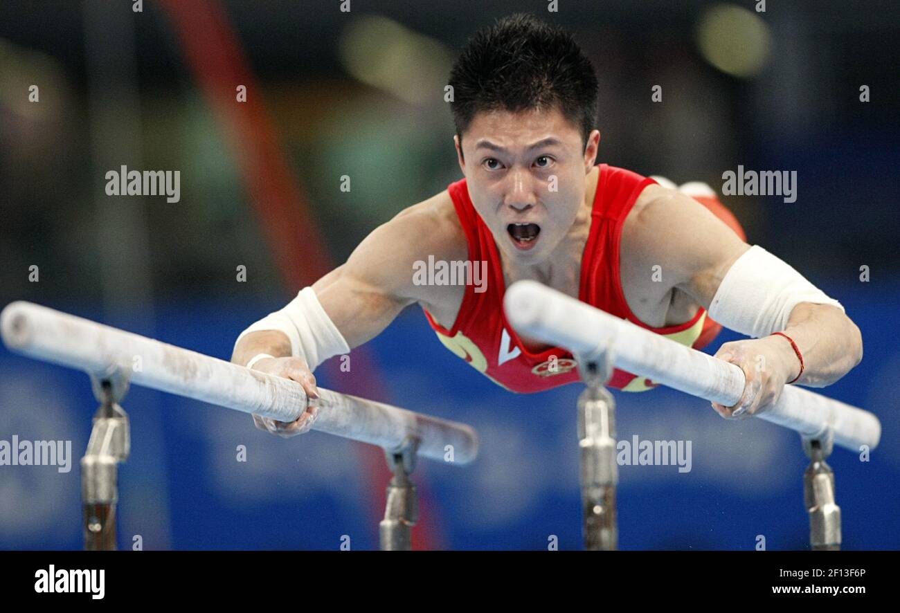 Li Xiaopeng of China competes on the parallel bars during qualifying ...
