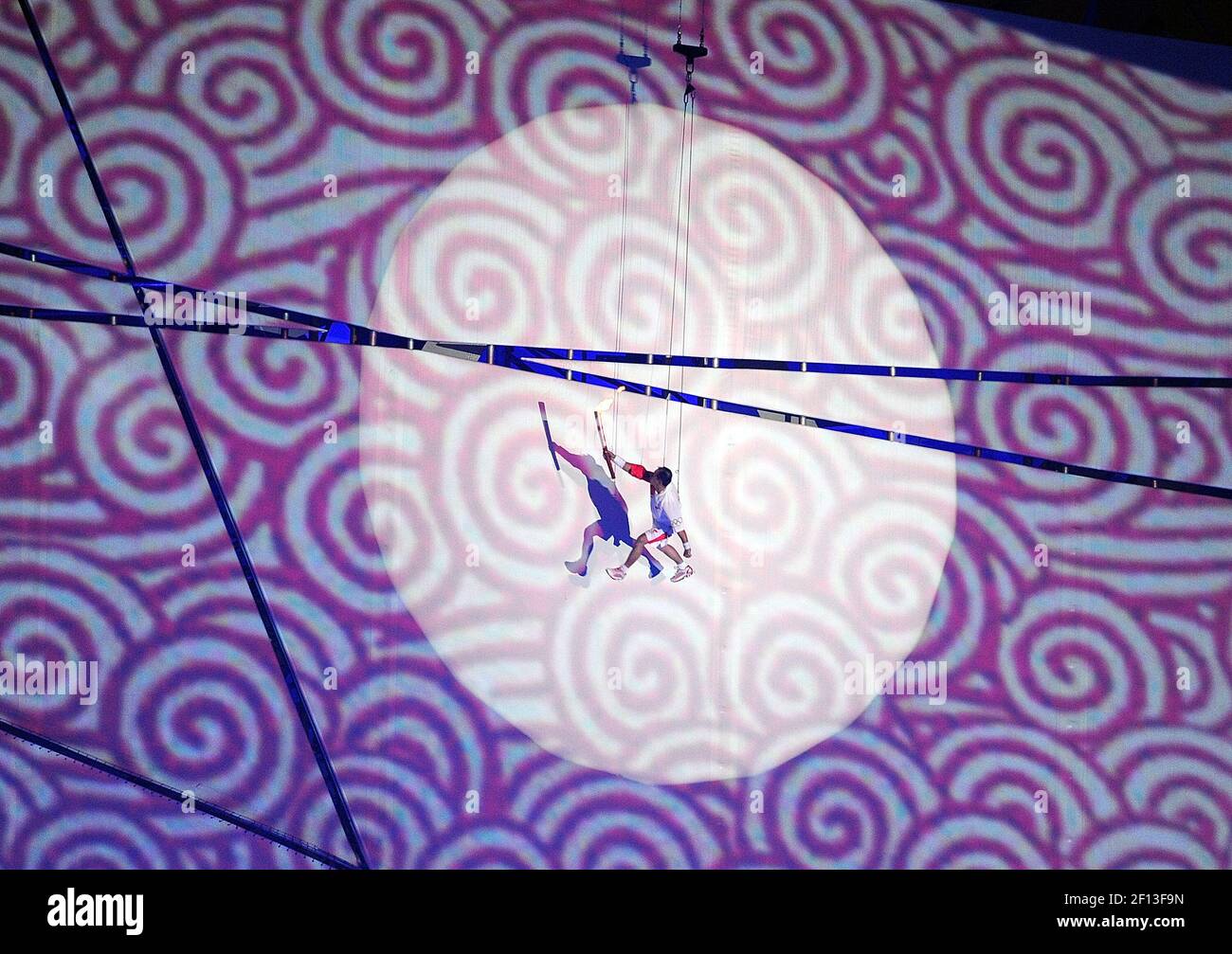 Li Ning flies as he carries the torch around the National Stadium ...