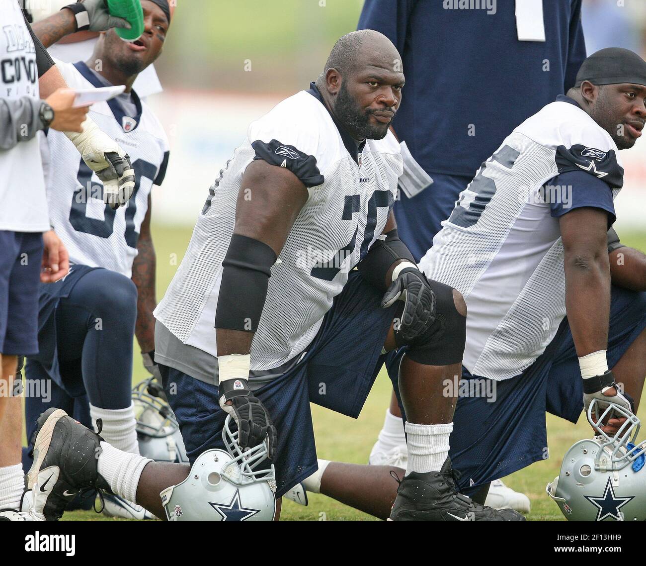 Dallas Cowboys tackle Leonard Davis (middle) takes a knee between plays ...