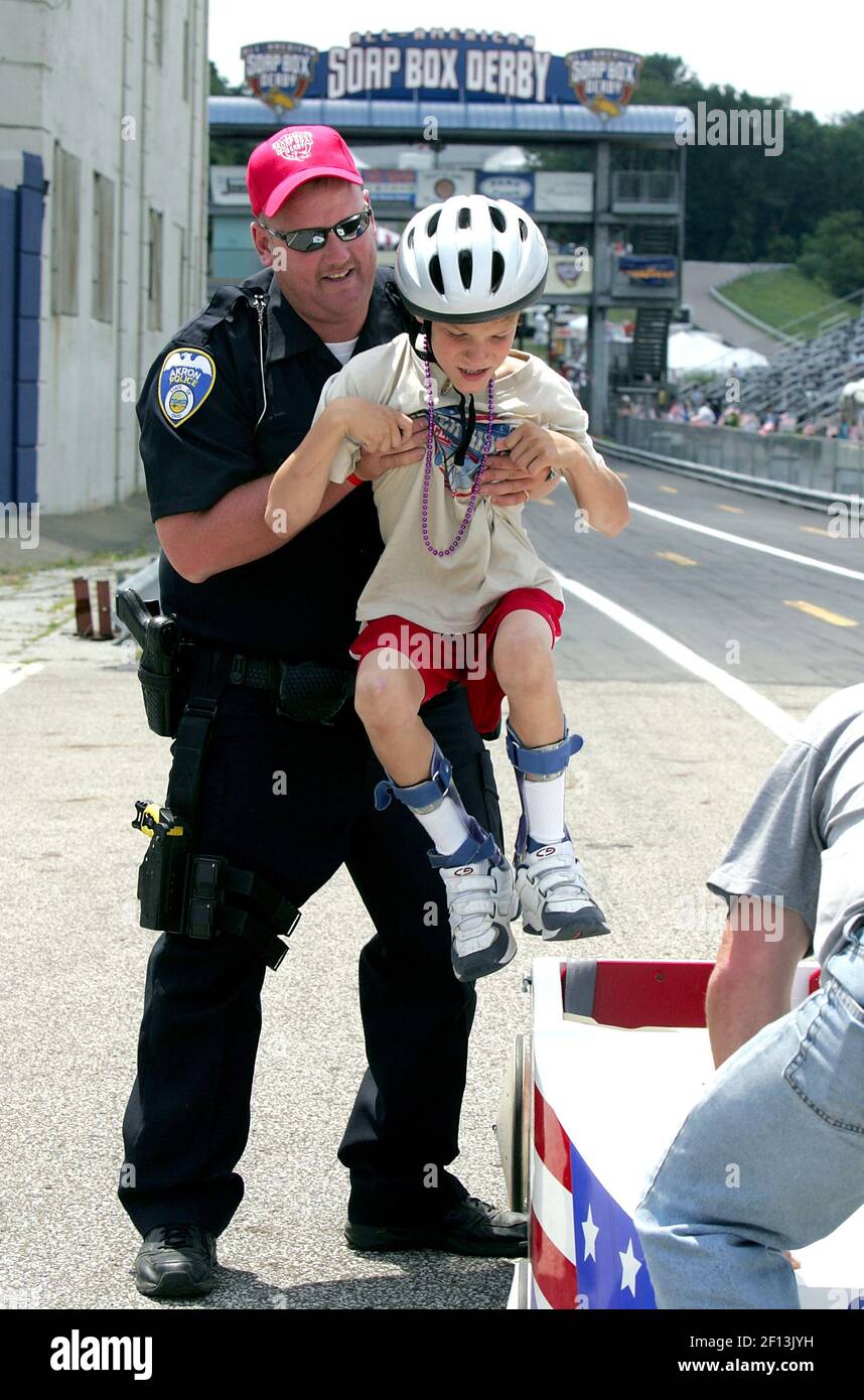 Akron Police Officer Kevin Cooper lends a hand to David Sellers of ...