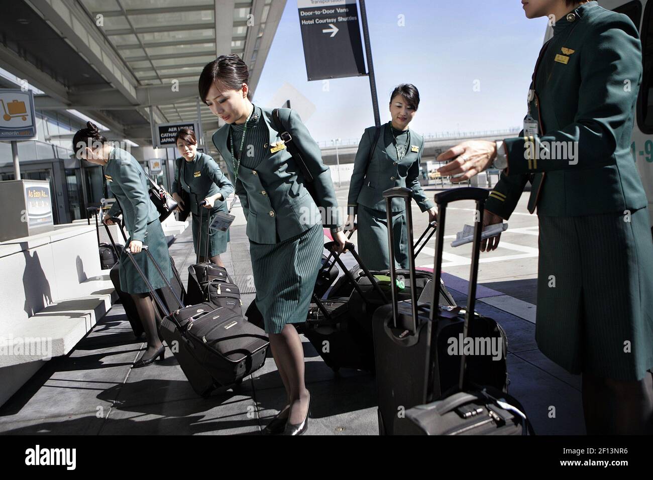 EVA Airways flight attendants make their way outside the terminal to ...