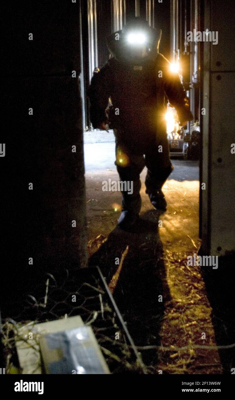 Army Staff Sgt. Sean Sandwick approaches a suspicious package backlit ...