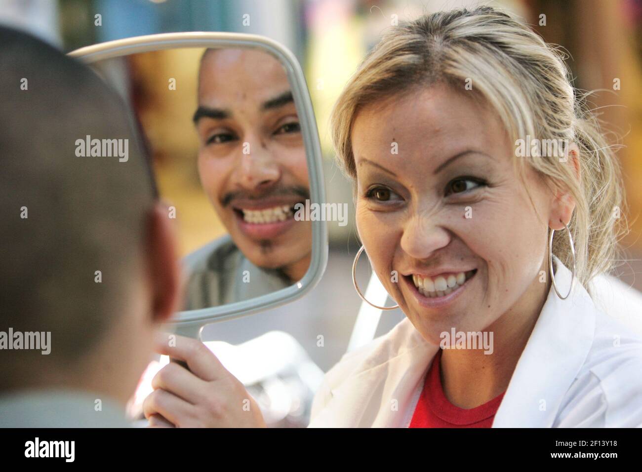 Paul Mondragon, left, checks out his teeth after a whitening treatment ...
