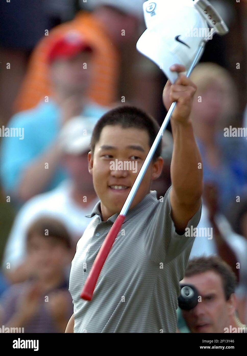 Anthony Kim lifts his hat and putter in the air after winning the ...