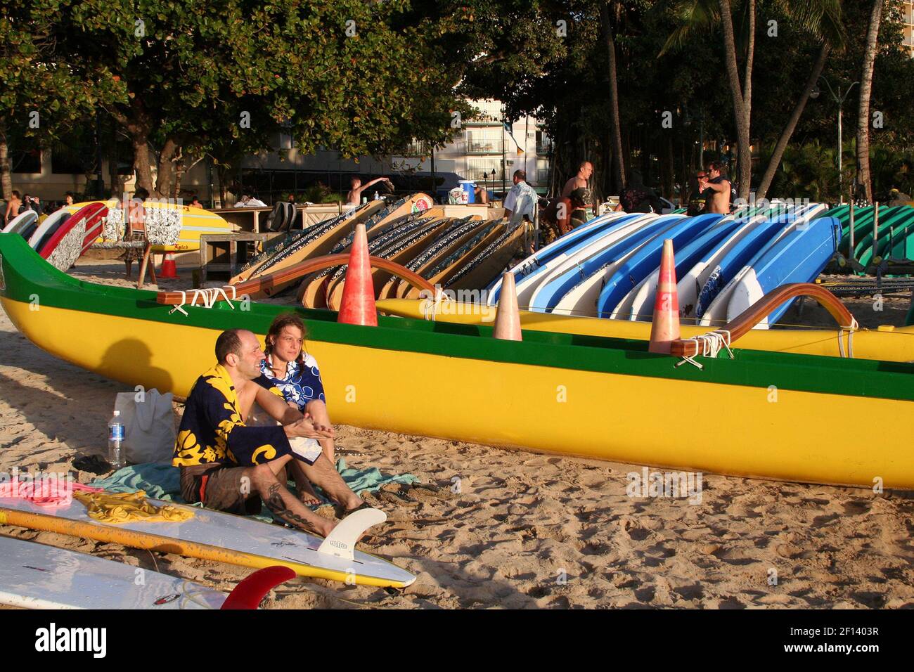 Sunbathers stake their claim beside an outrigger canoe on Waikiki Beach ...