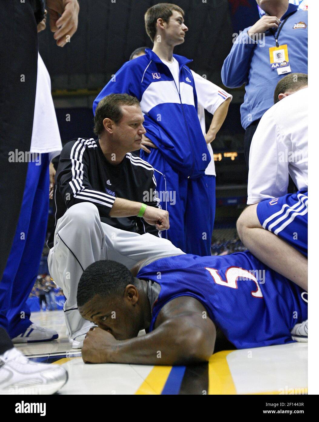 Kansas guard Rodrick Stewart lays on the court while head coach Bill ...