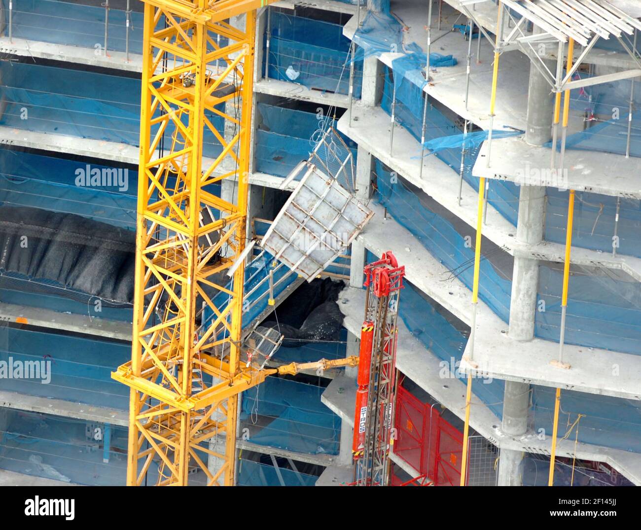 A portion of supports on a building dangles near the area where a ...