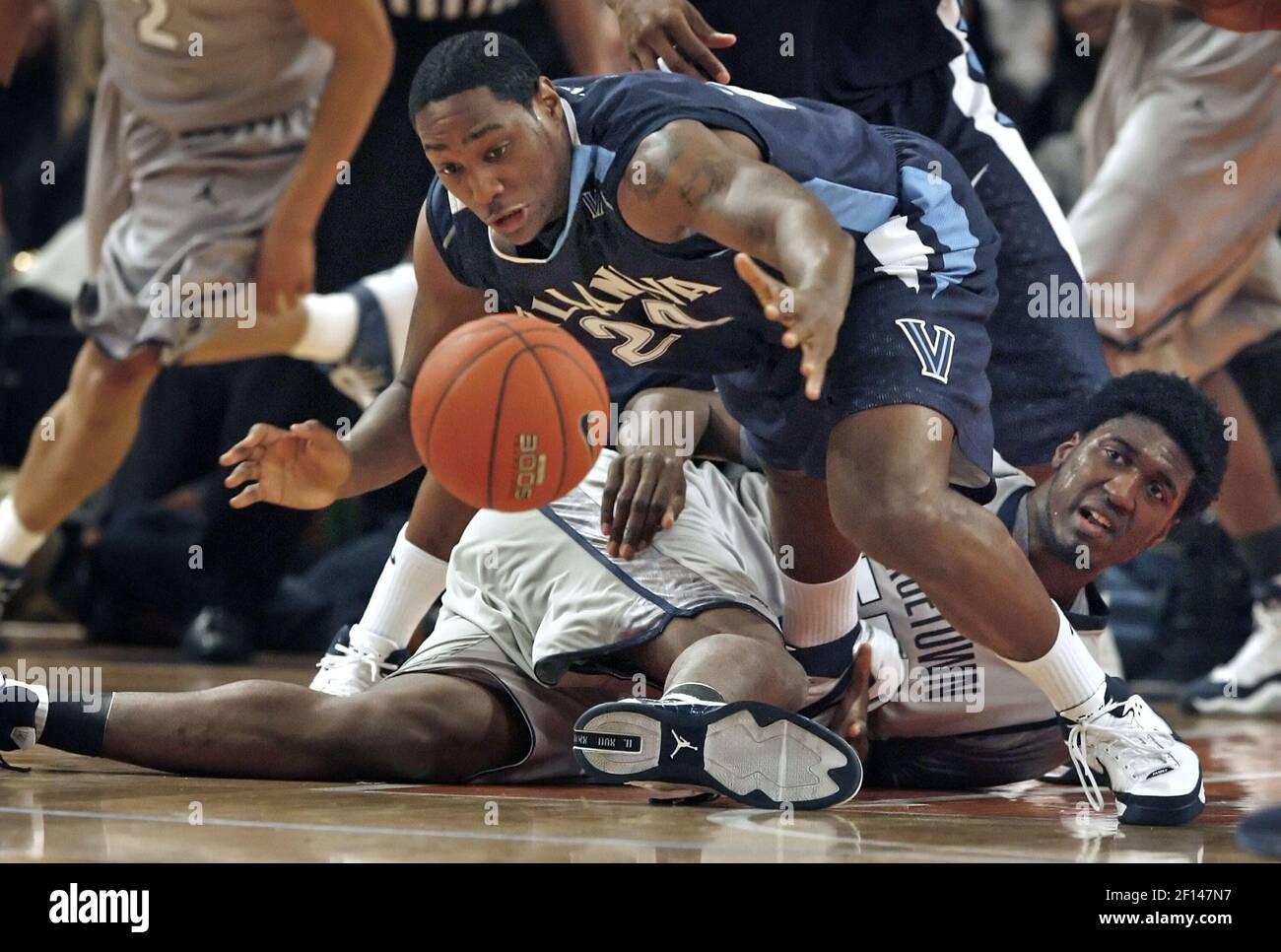 Villanova's Corey Stokes, top, dives for a loose ball in front of ...
