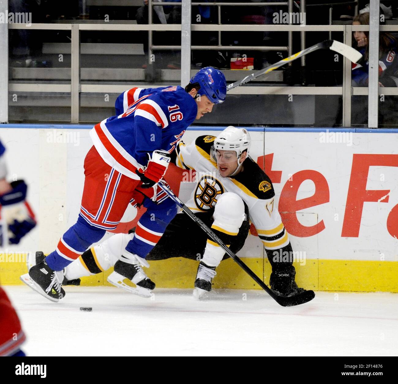 New York Rangers' Sean Avery runs over Boston Bruins' Milan Lucic along ...